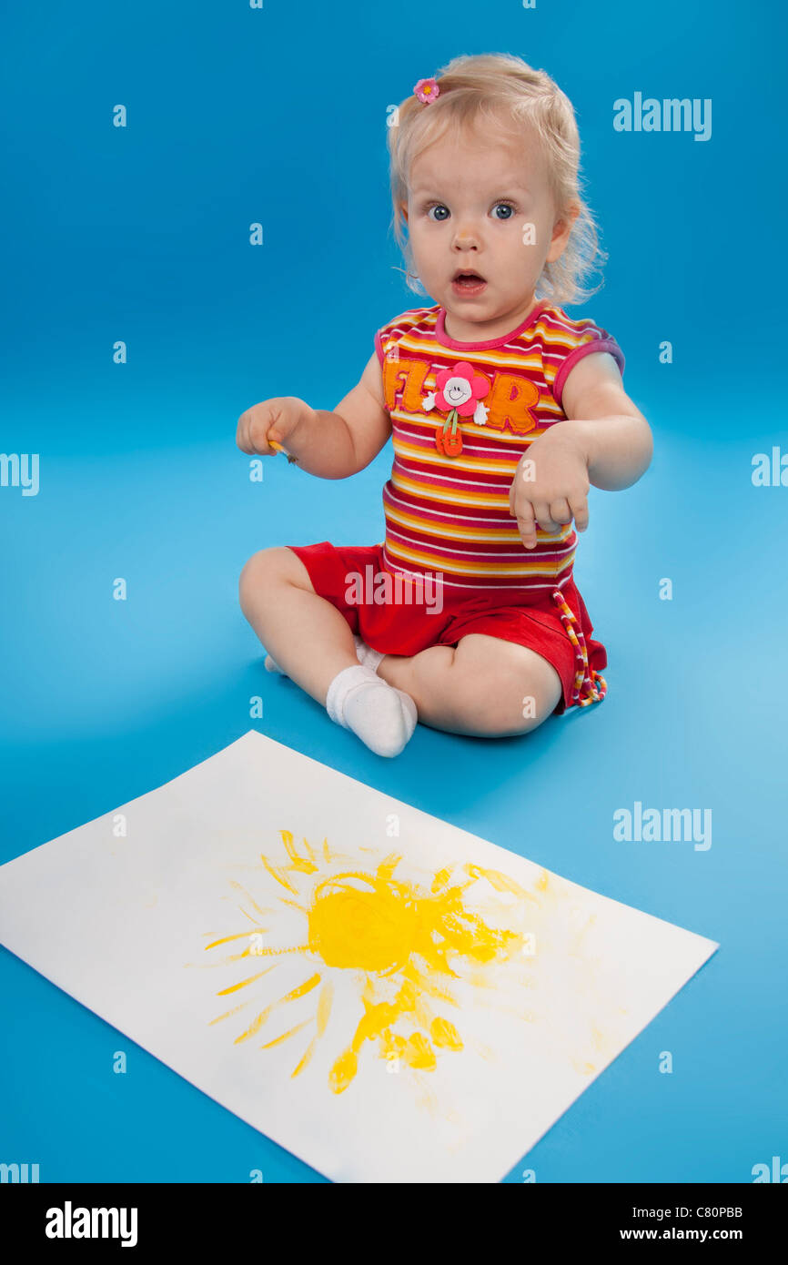 Small artist draw paints the sun. Isolated blue Stock Photo - Alamy