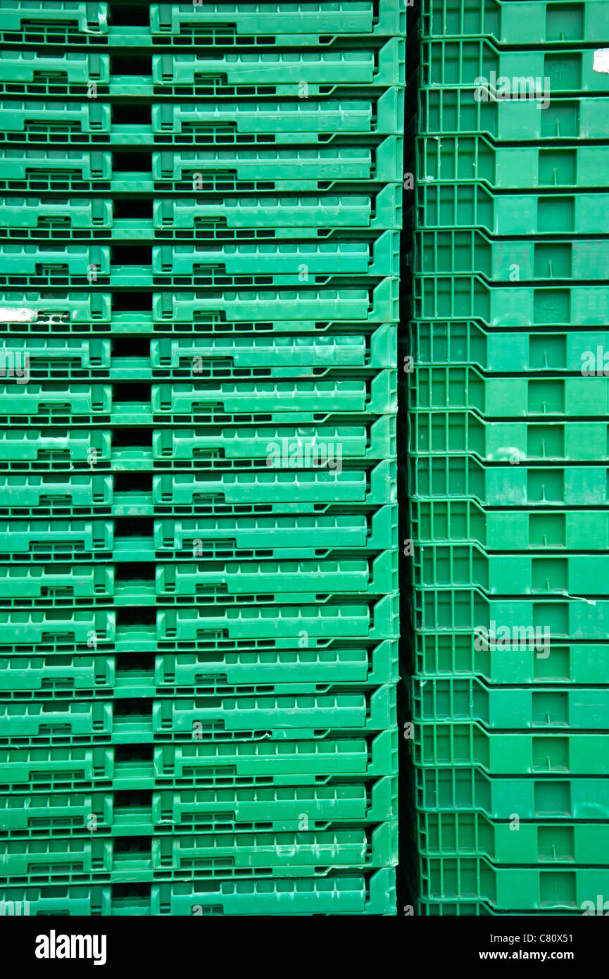 Green plastic storage boxes stacked up photographed close in to make ...