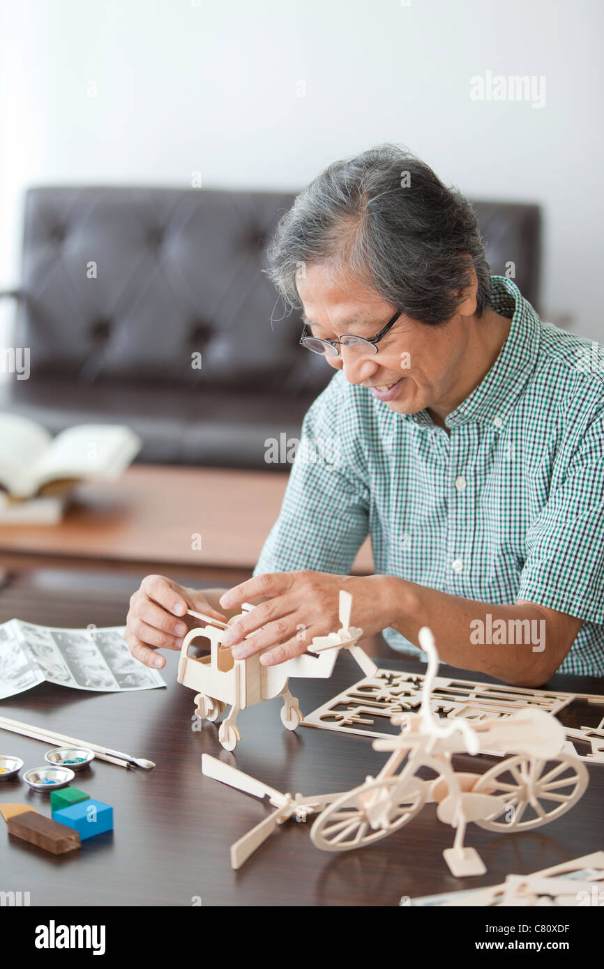 Senior Man Building Wooden Models Stock Photo - Alamy