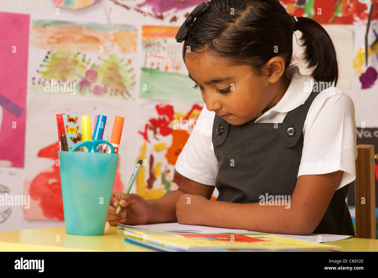A young school girl writing Stock Photo - Alamy