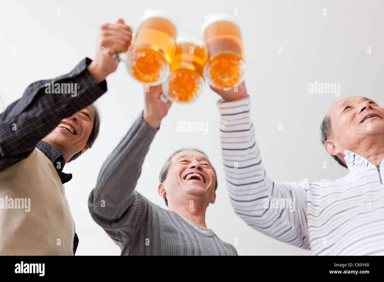 Three Senior Men Toasting with Pint Stock Photo - Alamy