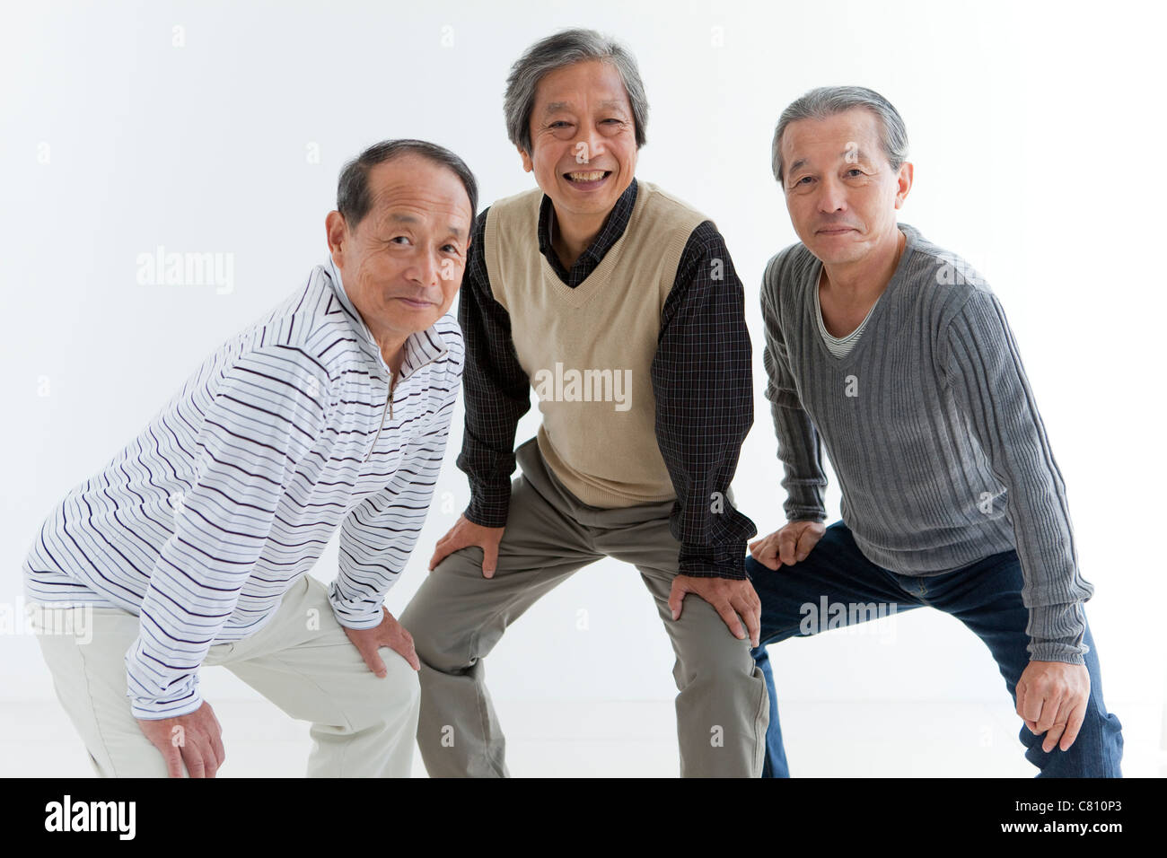 Three Cheerful Senior Men Crouching Stock Photo - Alamy