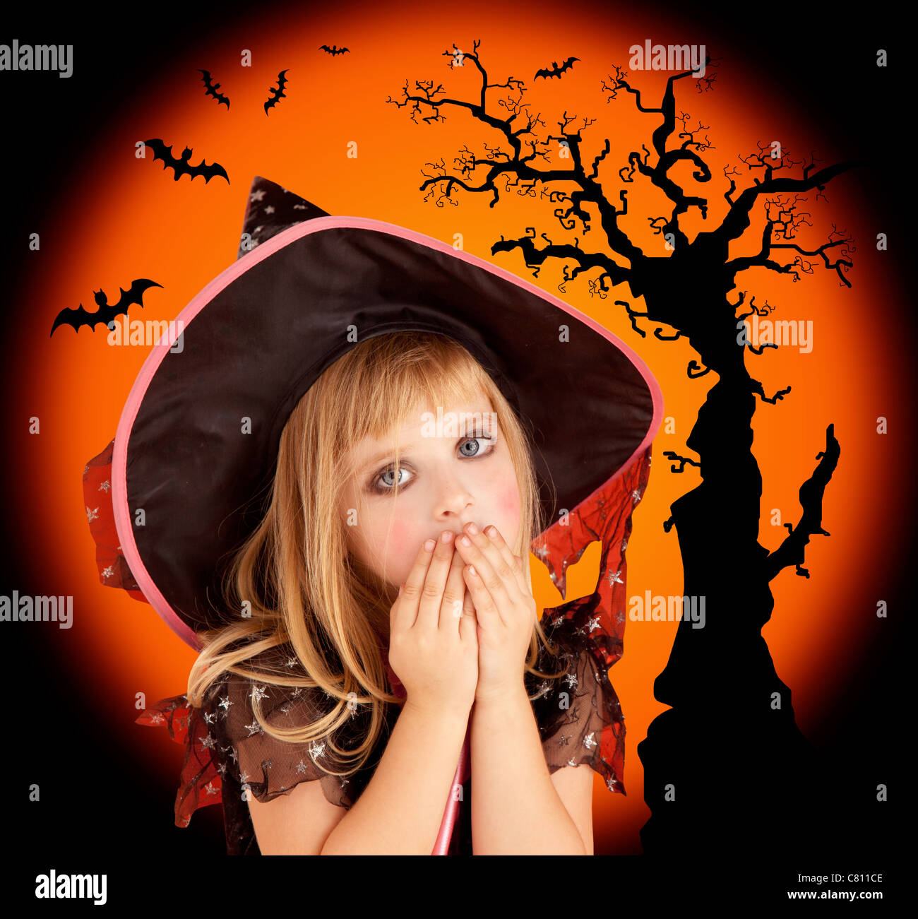 Halloween scared kid girl on orange background Stock Photo - Alamy