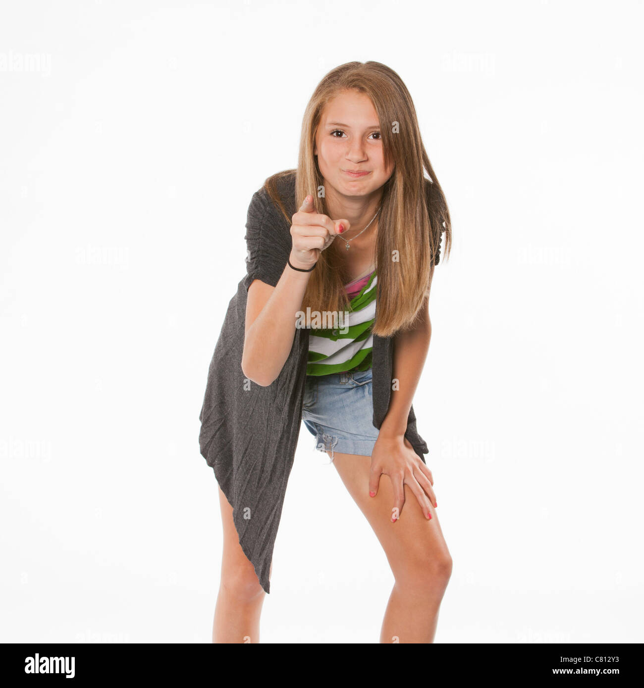 A happy active pretty teenage female girl pointing isolated against a ...