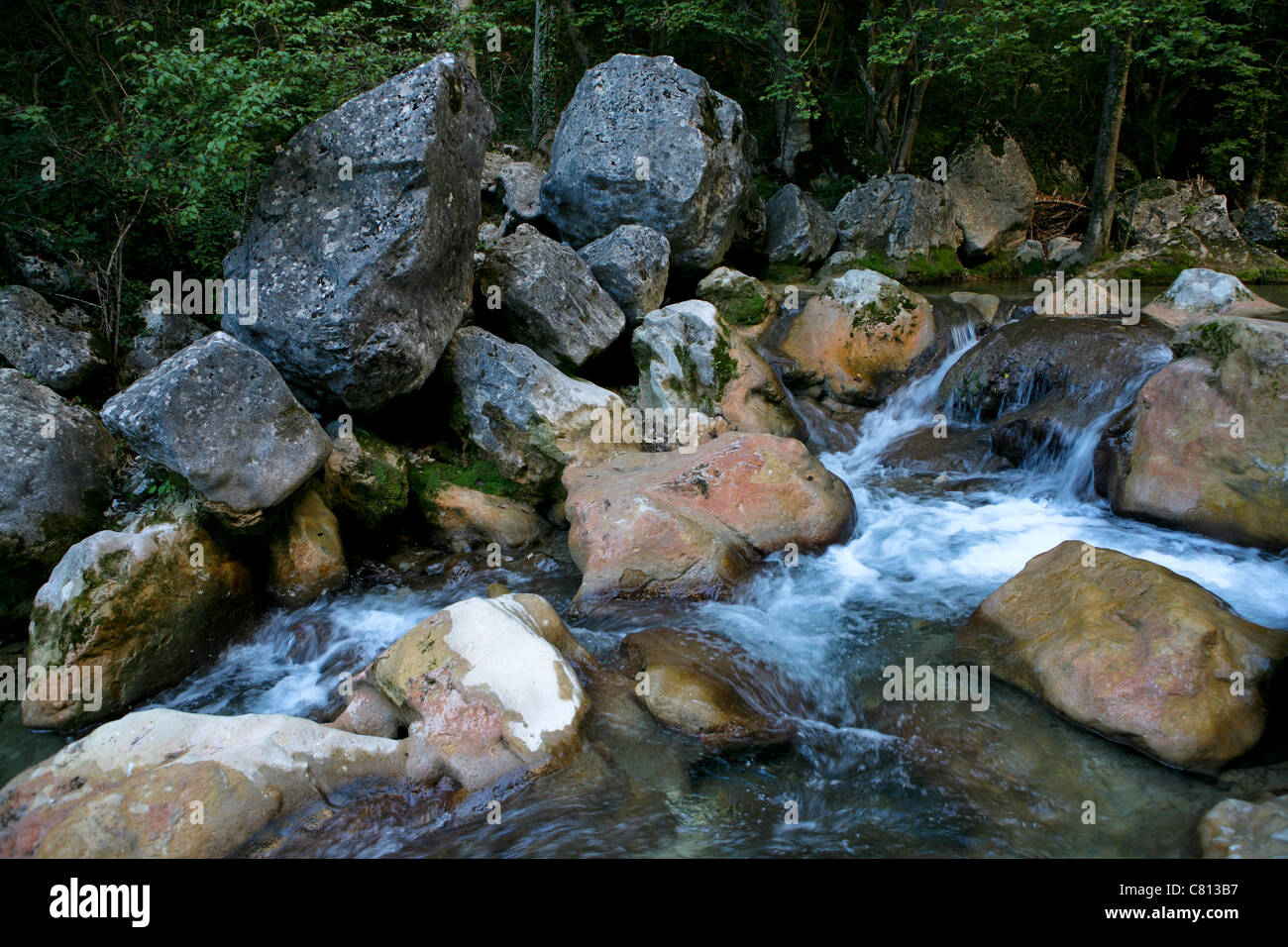 River / water flowing over and around large rocks Stock Photo - Alamy