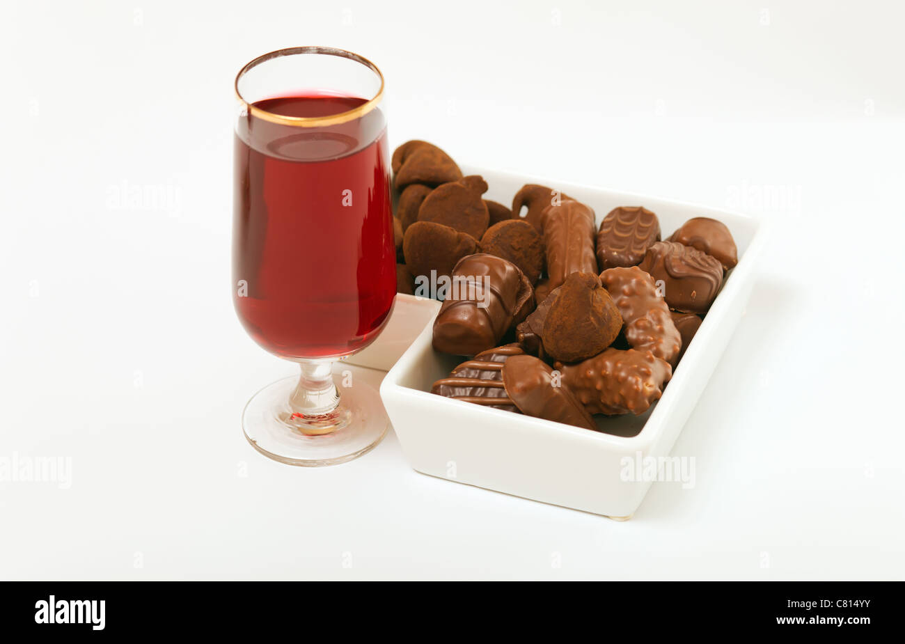 Cherry brandy and chocolates on a white table Stock Photo - Alamy