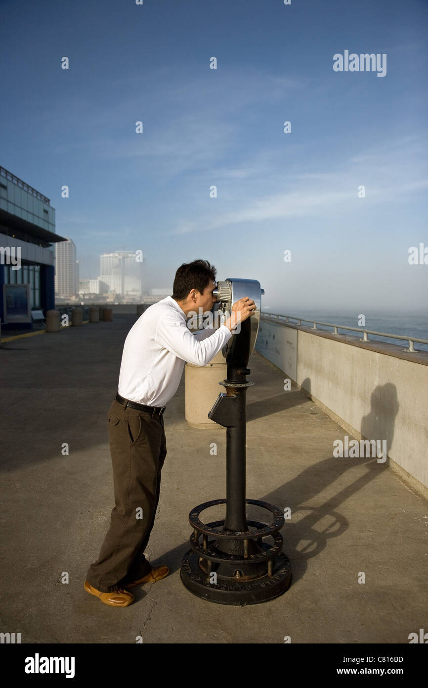 Man looking through a viewer over the Atlantic Ocean in Atlantic City ...