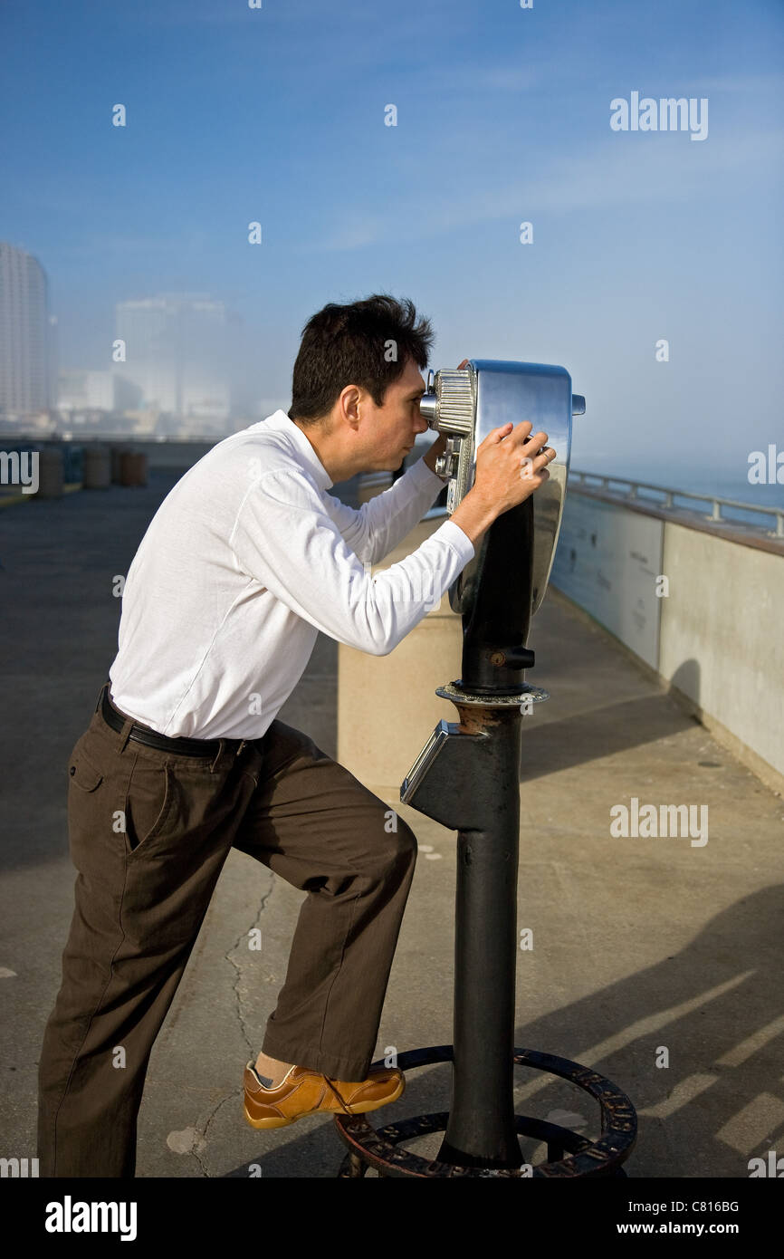 Man looking through a viewer over the Atlantic Ocean in Atlantic City ...