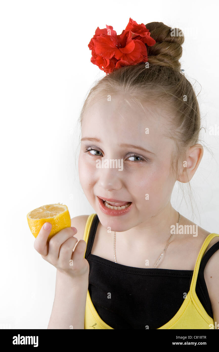 A little cute girl eating an lemon Stock Photo - Alamy