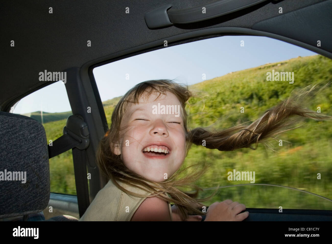 Little fun girl speeds in car near the open window Stock Photo - Alamy