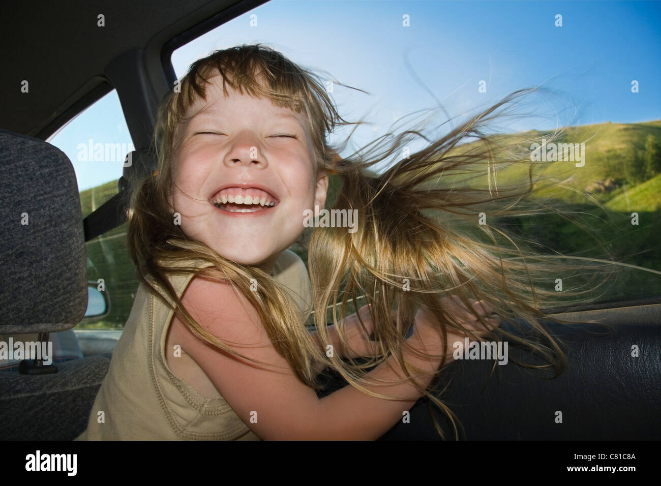Little fun girl speeds in car near the open window Stock Photo - Alamy