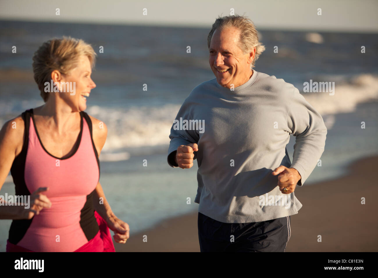 Couple running together on beach Stock Photo - Alamy