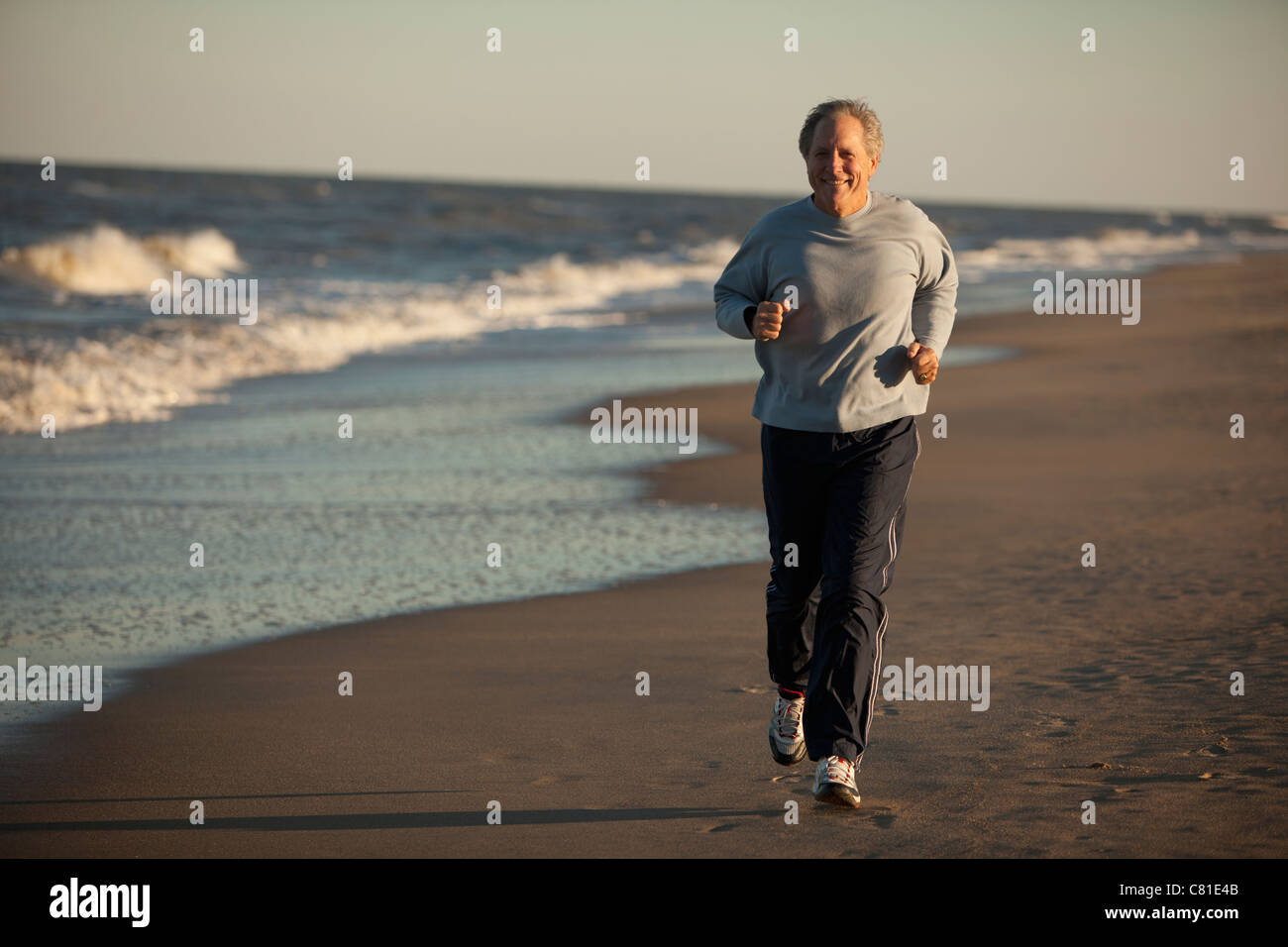 Man running on beach Stock Photo - Alamy