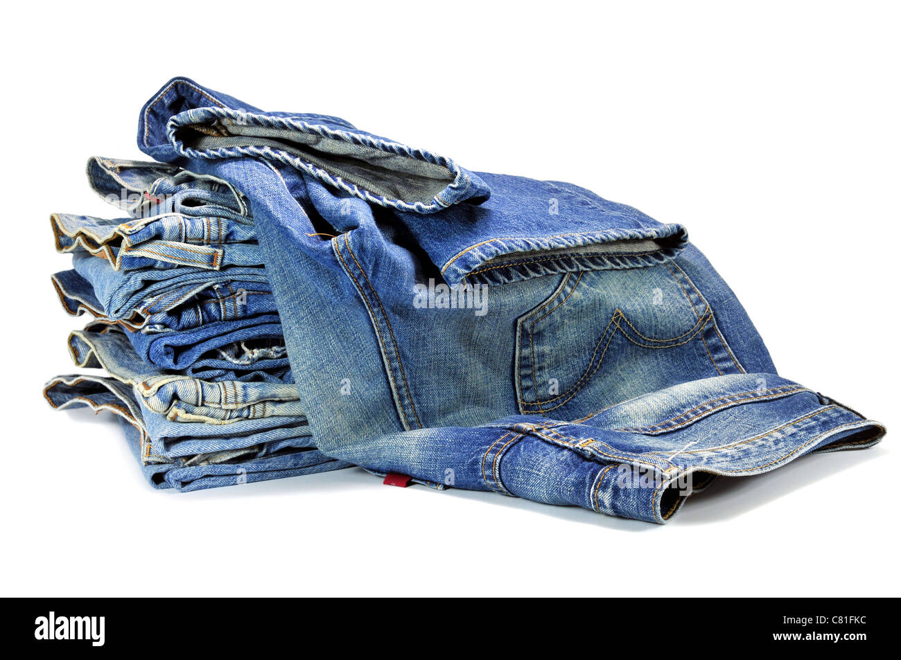 Pile of blue denim jeans on white background Stock Photo - Alamy