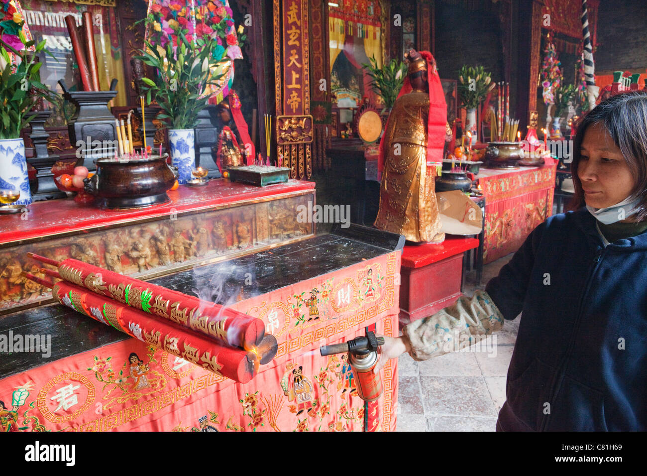 China, Macau, Sam Kai Vui Kun Temple, Temple Worker using Blow Torch to ...