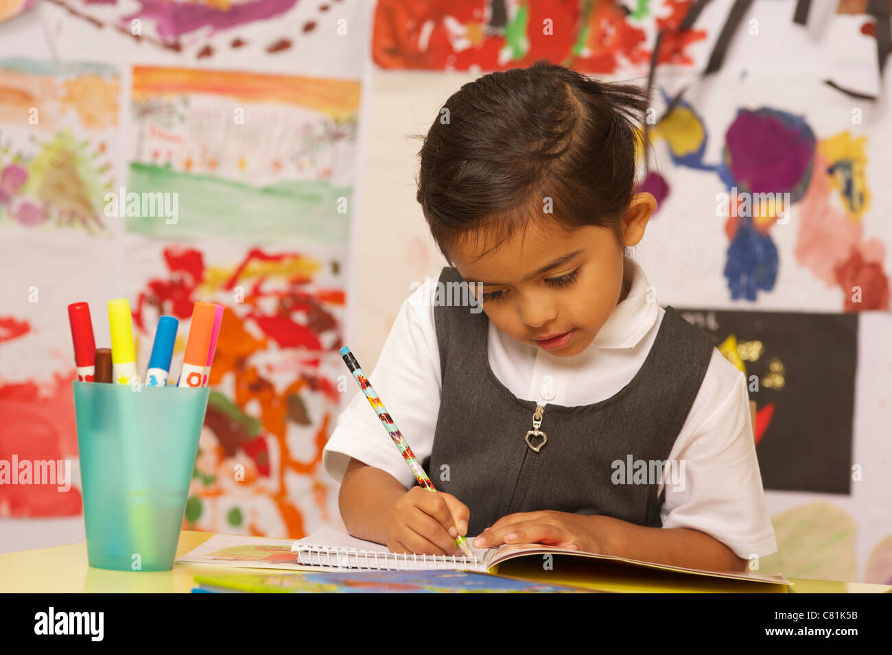 A young school girl writing, uk Stock Photo - Alamy