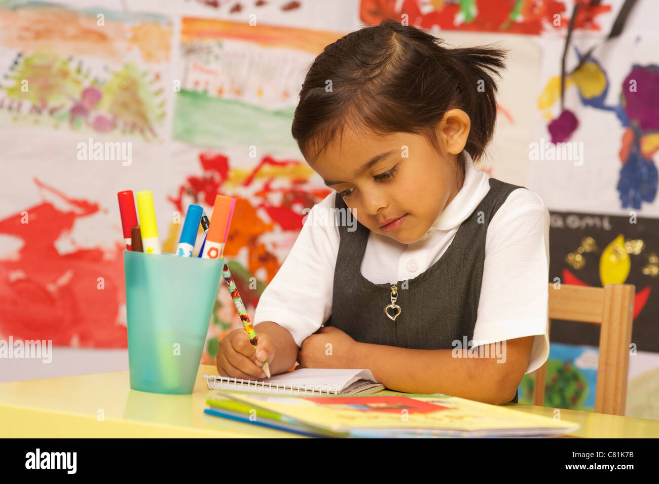 Young school girl writing Stock Photo - Alamy