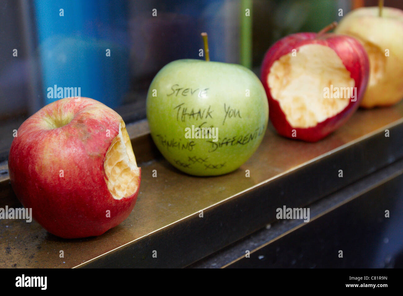 Fans leave flowers and apples with a bite out of them outside the Apple ...