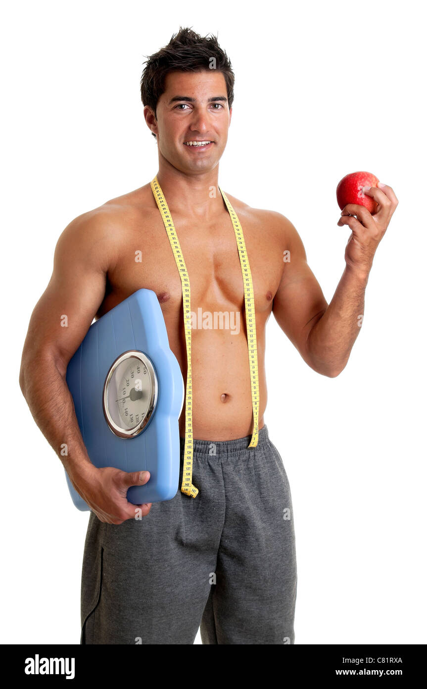 Muscular young man with apple and weight scale Stock Photo - Alamy
