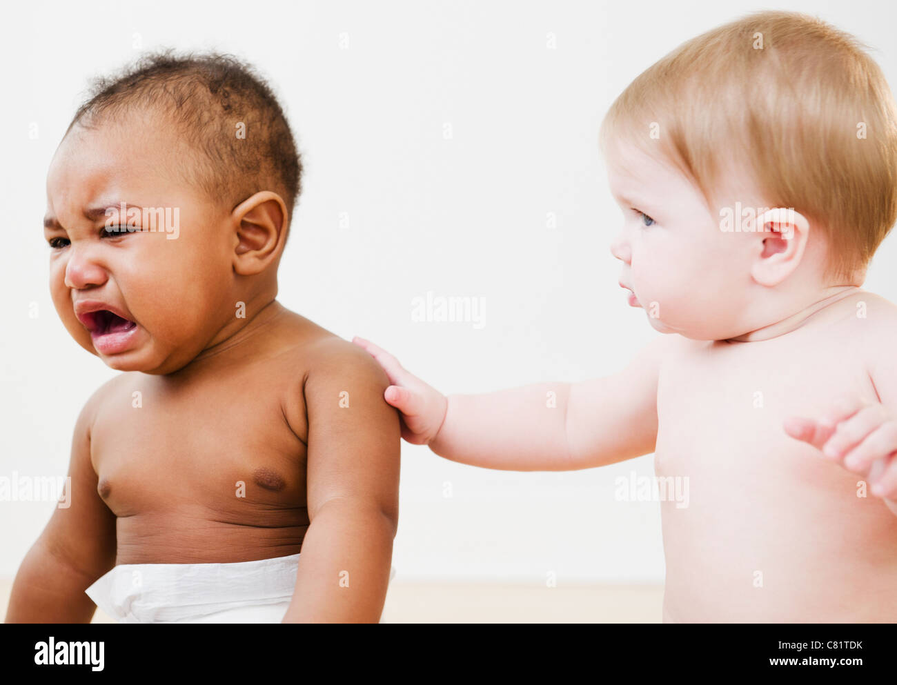 Baby consoling crying friend Stock Photo - Alamy
