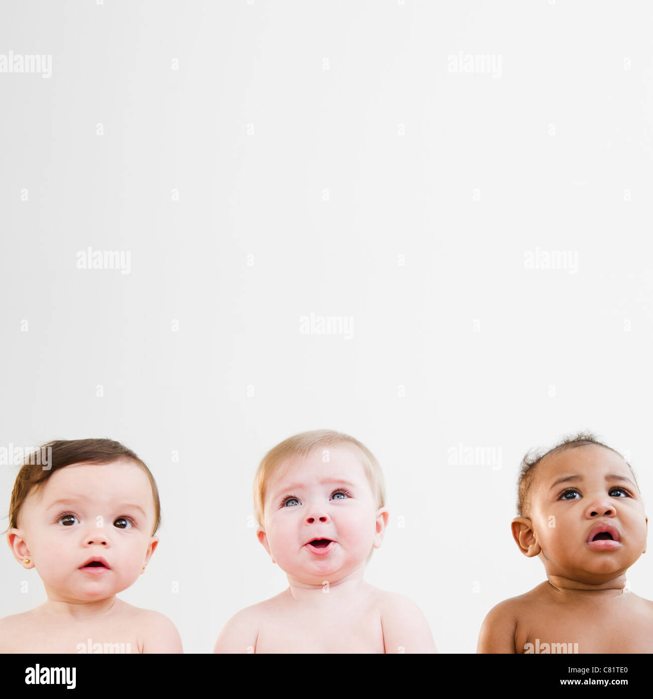Curious babies sitting in a row Stock Photo - Alamy