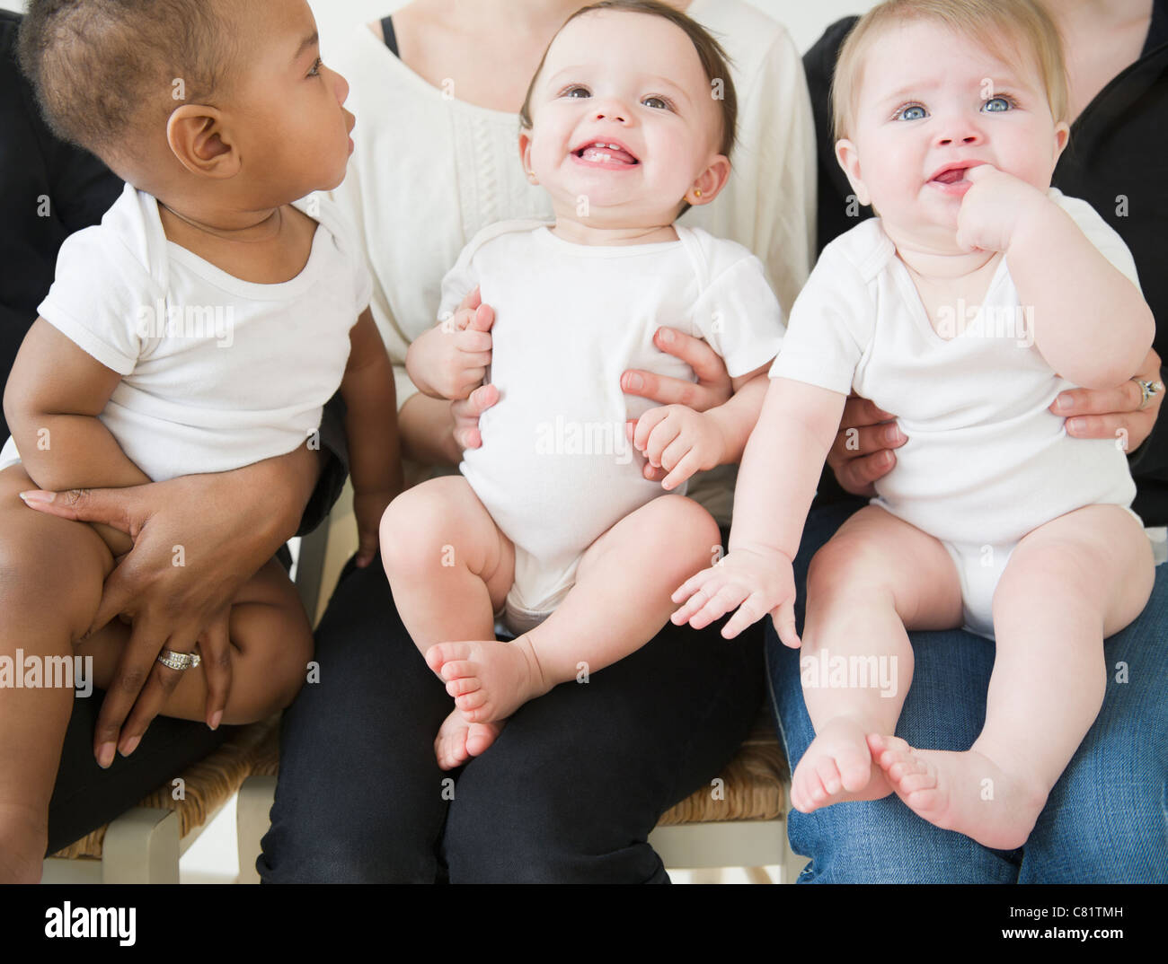 Mothers holding babies on their laps Stock Photo - Alamy