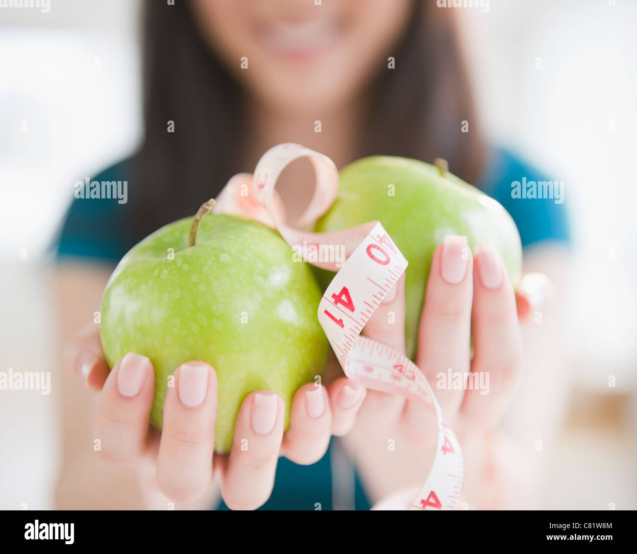 Korean woman holding apples and tape measure Stock Photo - Alamy