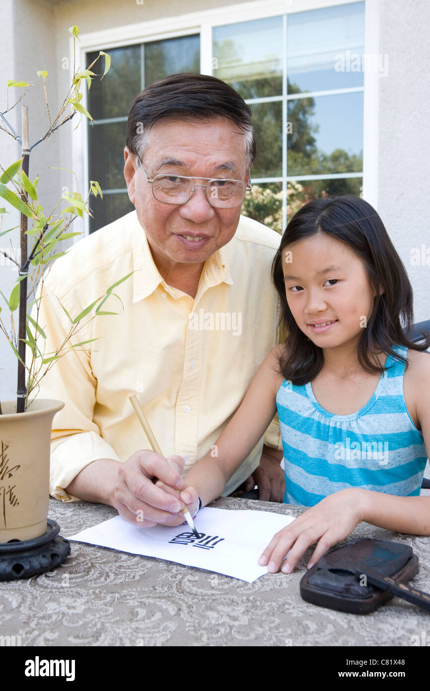 Chinese grandfather teaching granddaughter calligraphy Stock Photo - Alamy