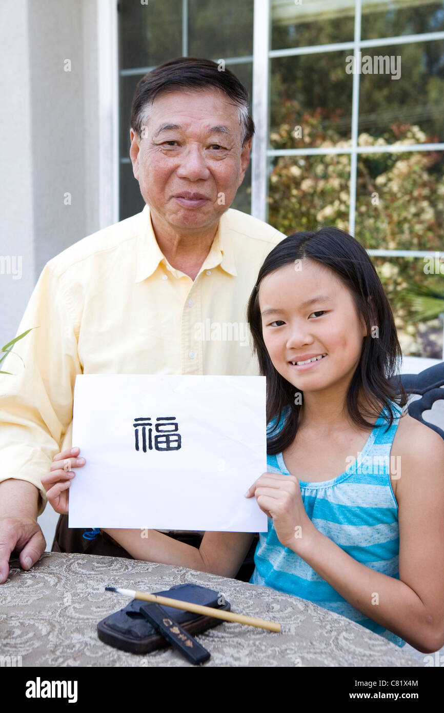 Chinese grandfather teaching granddaughter calligraphy Stock Photo - Alamy