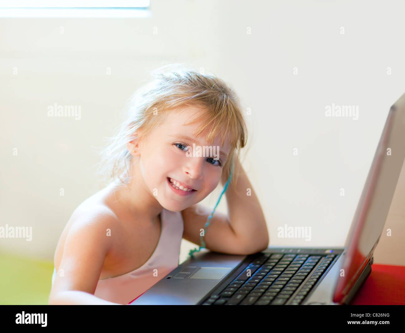 blond children girl smiling with computer laptop Stock Photo - Alamy