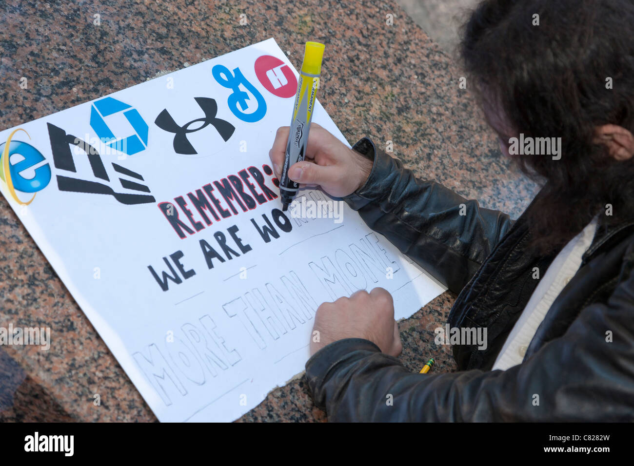 A man creates a protest sign using a magic marker during the Occupy ...