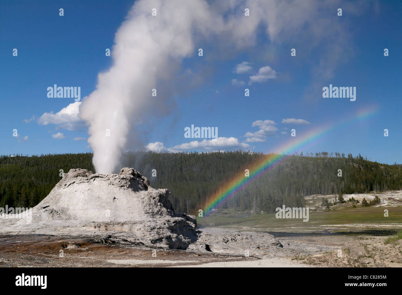 Castle Geyser erupting and rainbow in Yellowstone National Park ...