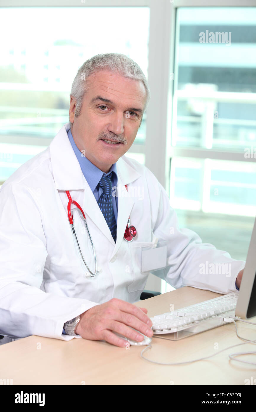 Doctor working on his computer Stock Photo - Alamy