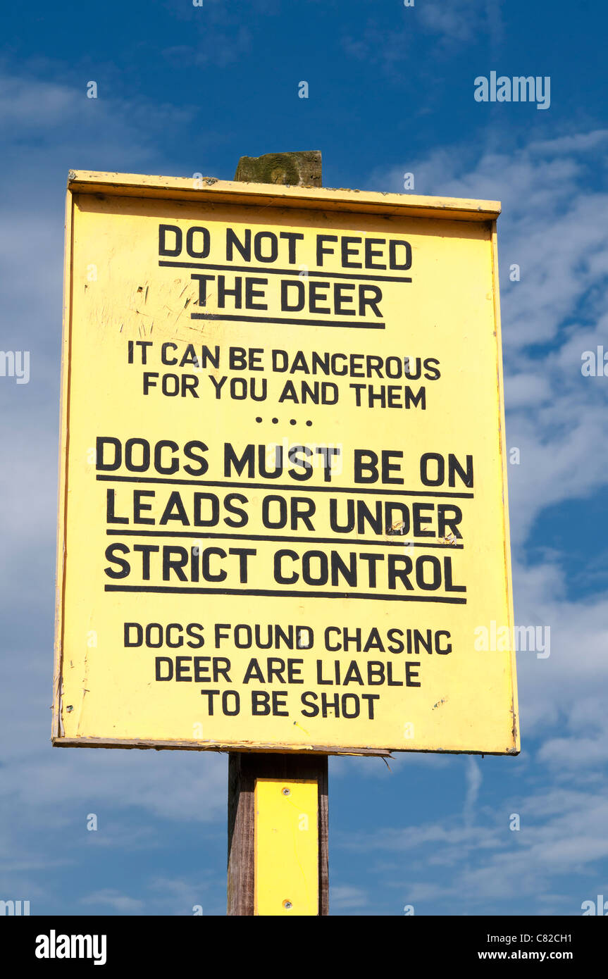 Do not feed the deer sign advising visitors to keep dogs on leads or ...