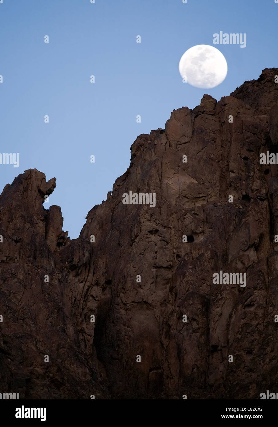 big low moon over a mountain on blue sky background Stock Photo - Alamy