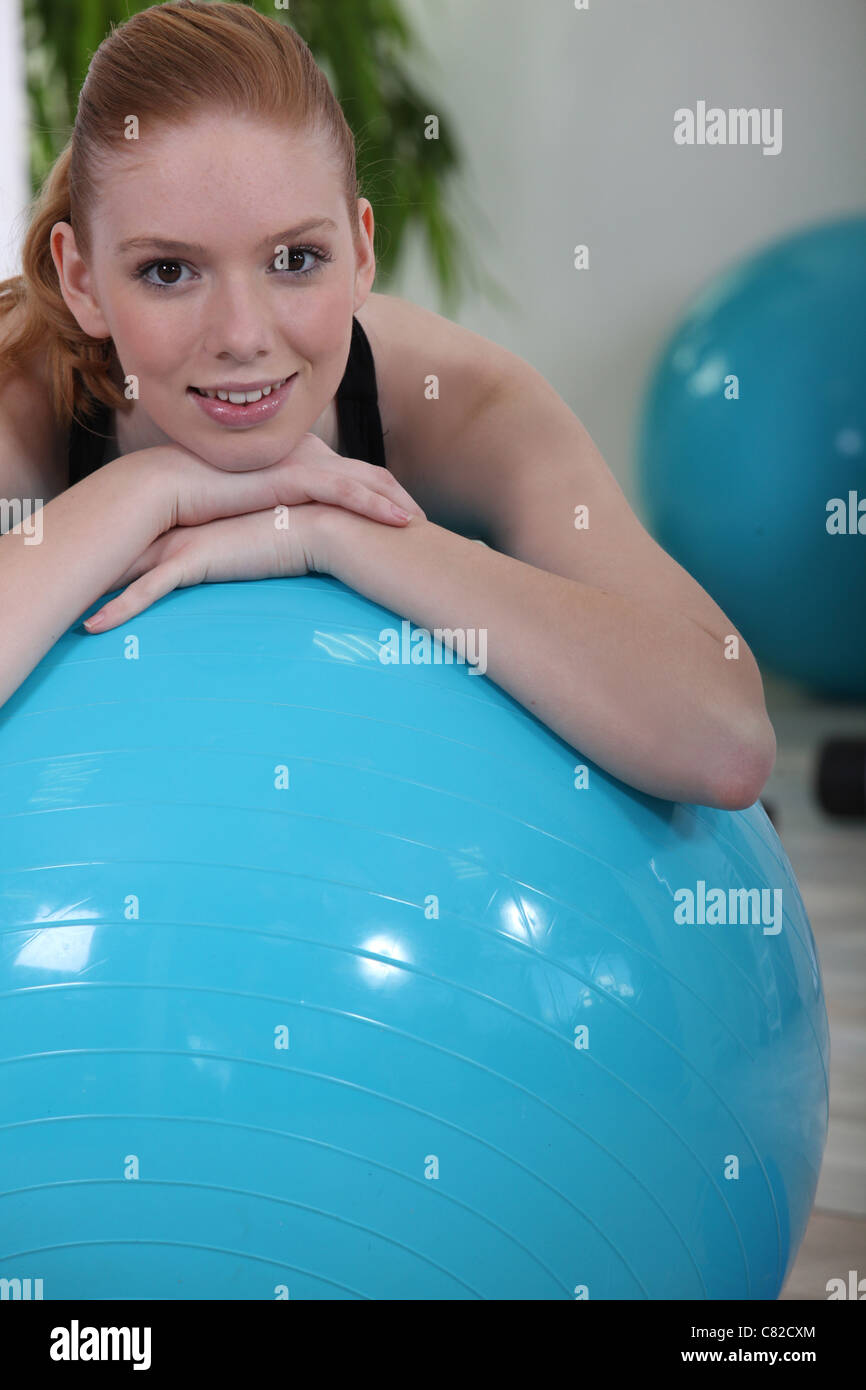Woman using an exercise ball in a gym Stock Photo - Alamy
