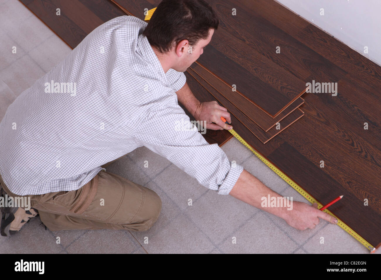 Man measuring wooden flooring Stock Photo - Alamy