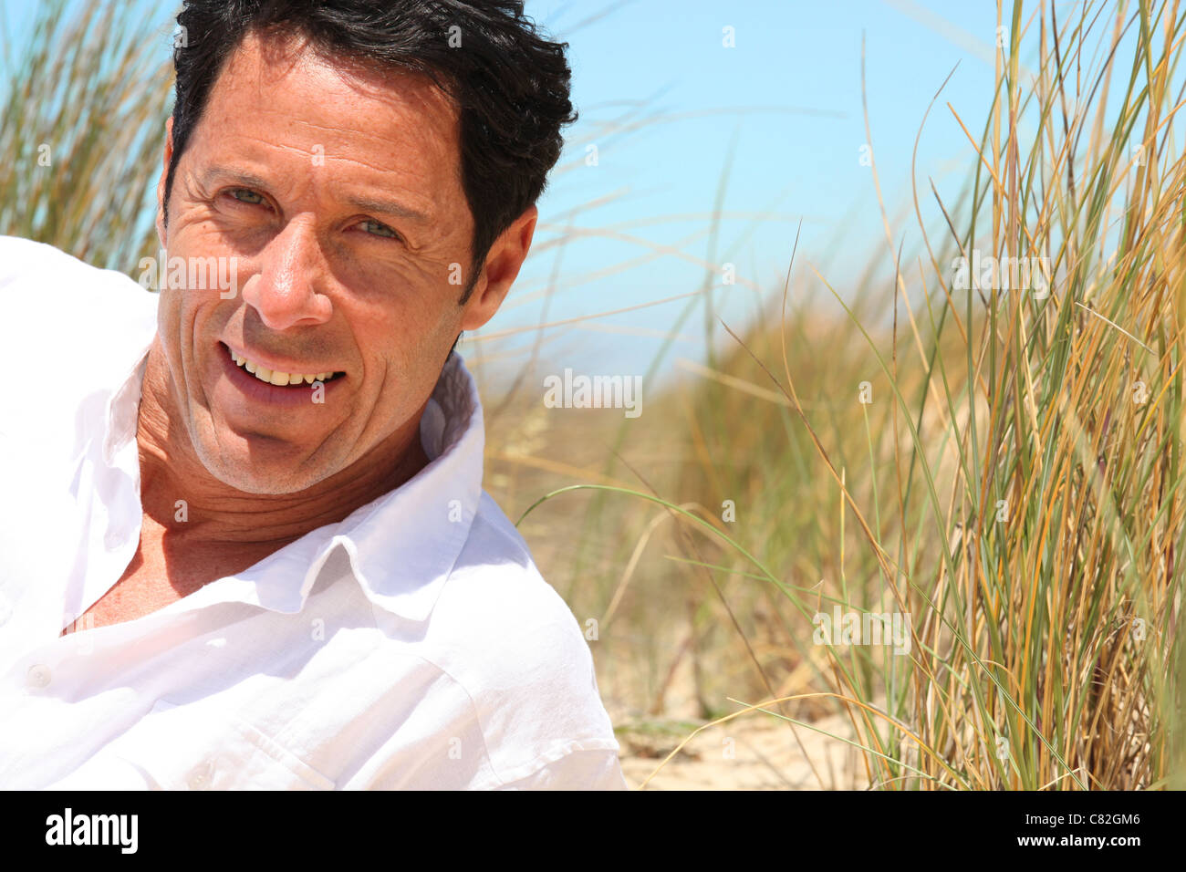 Man smiling on the beach Stock Photo - Alamy
