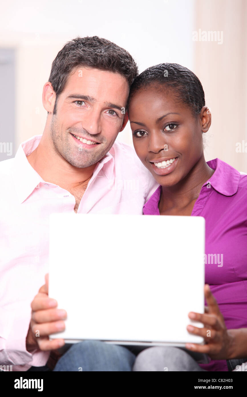 mixed couple heads joined with laptop Stock Photo - Alamy