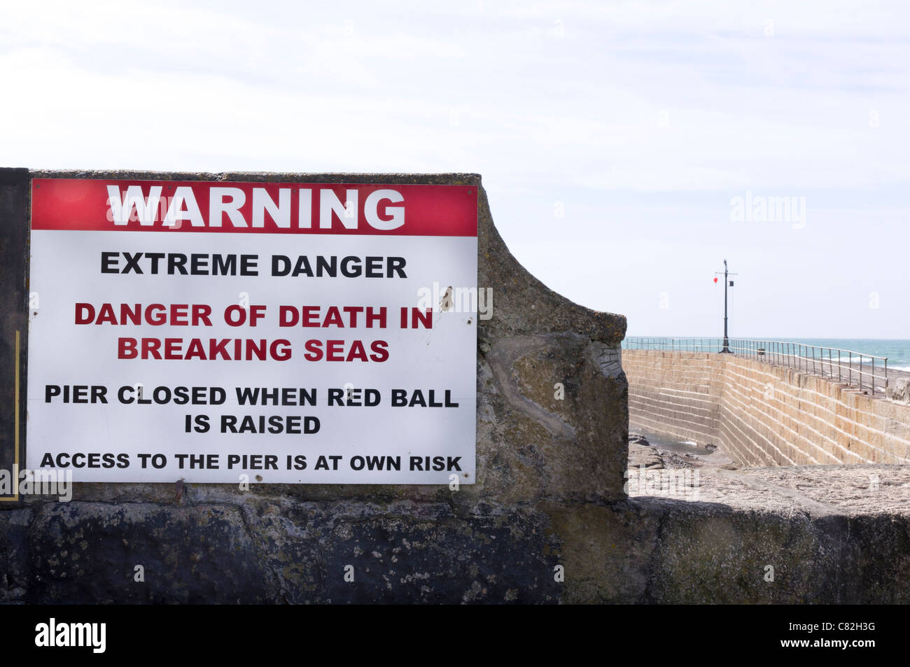 Warning sign on harbour wall Stock Photo - Alamy
