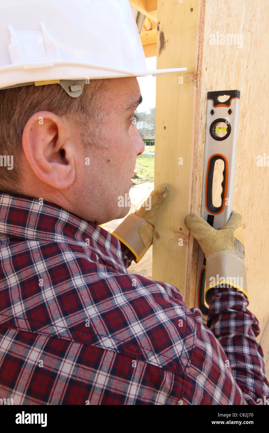 Builder using a spirit level Stock Photo - Alamy