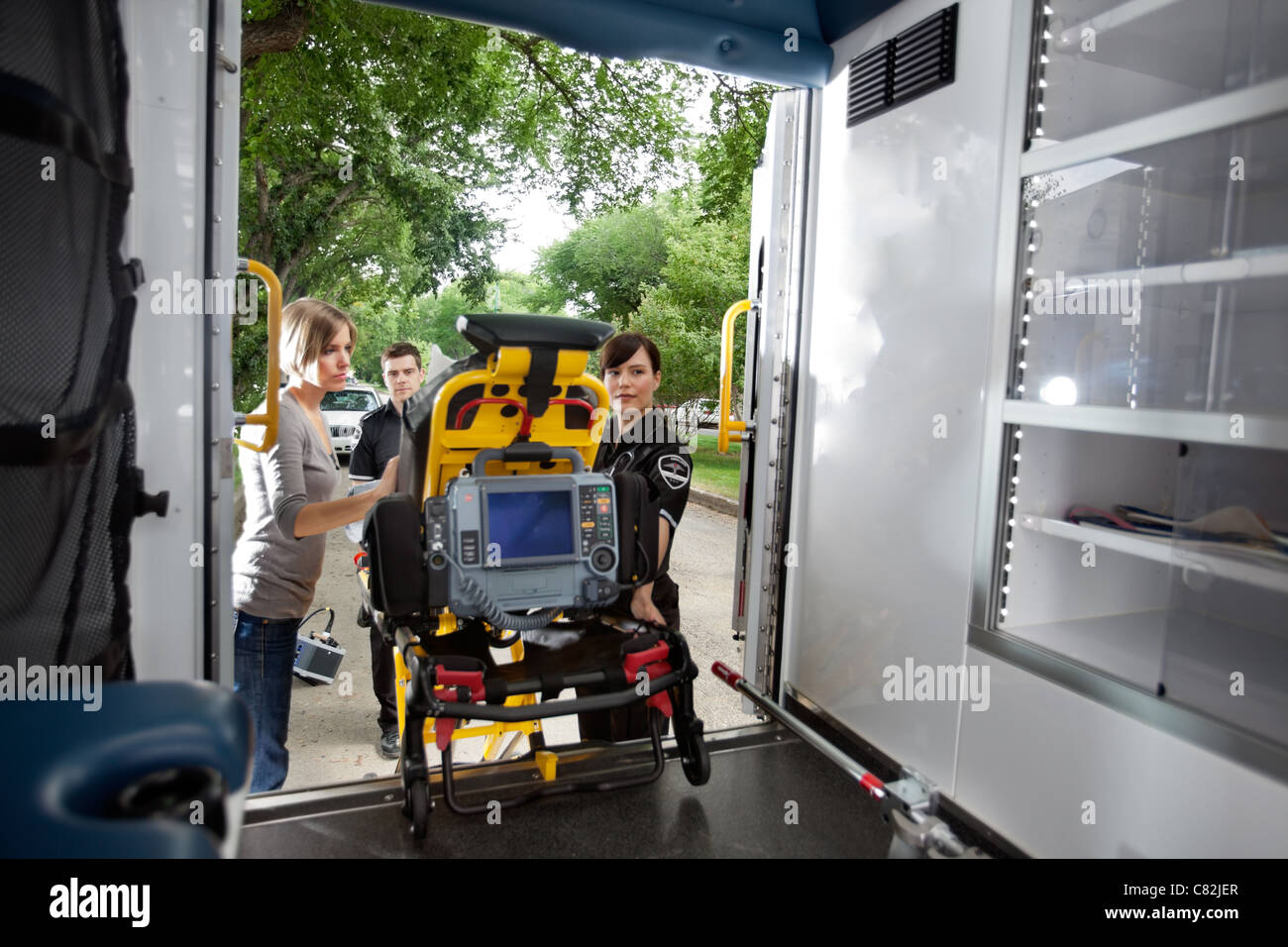 Emergency team loading patient in ambulance, caregiver at side Stock ...
