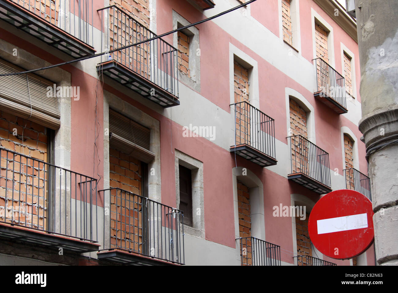 No Entry sign against pink and white wall with bricked up windows and ...