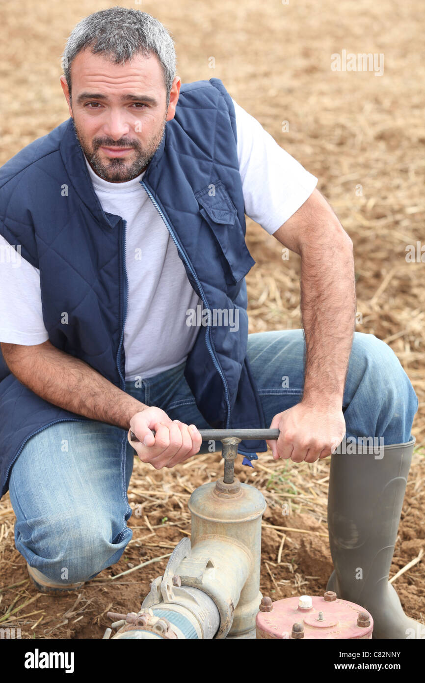 Farmer opening a water pipe Stock Photo - Alamy