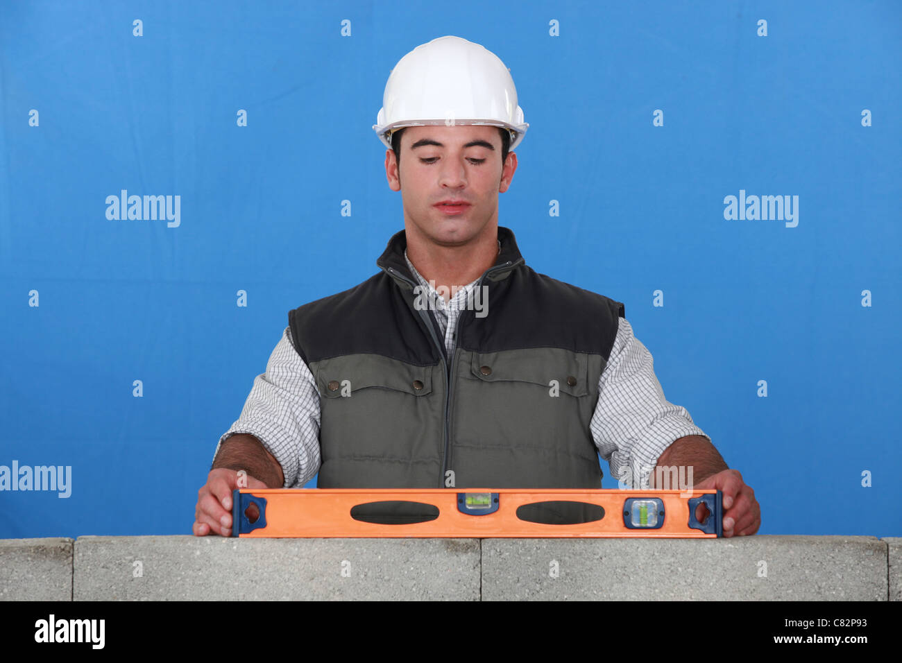 Bricklayer with a spirit level Stock Photo - Alamy