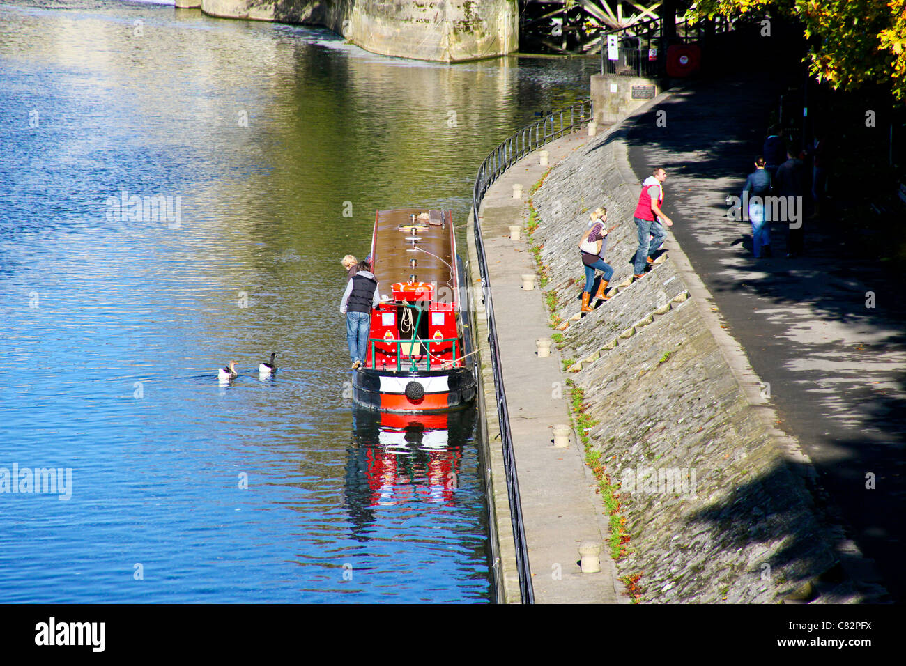 Narrow boat moored on the River Avon below Pulteney Weir in Bath, N.E ...