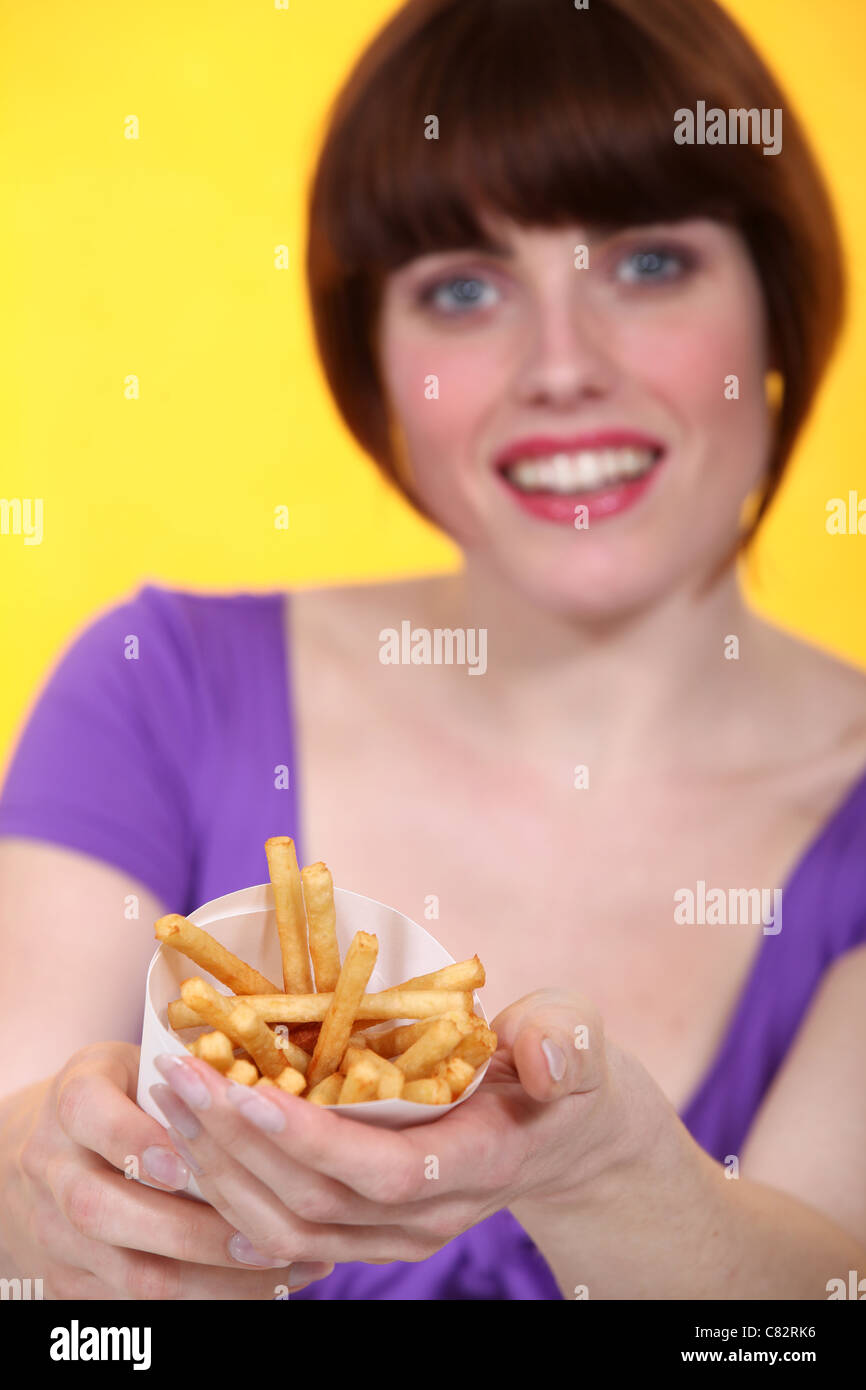 Young woman proposing French fries Stock Photo - Alamy