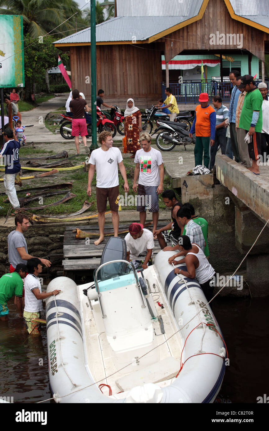 Visiting surfers prepare for a days tidal bore surfing on the Kampar ...