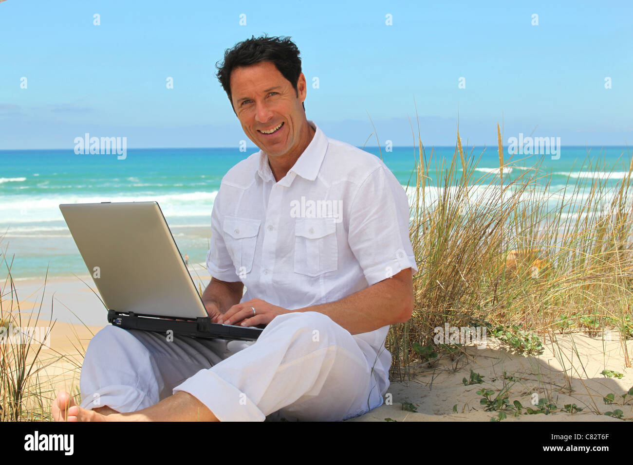 Man working on the beach Stock Photo - Alamy