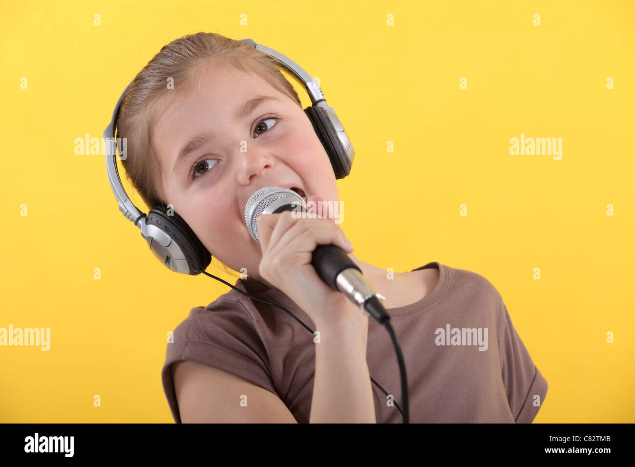 Little girl with microphone and headphones Stock Photo - Alamy